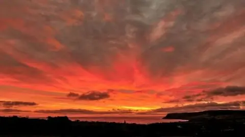 In pictures: Salt and Saharan sands turn seaside skies pink and purple