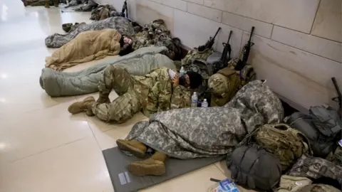 National Guard: President Biden apologises over troops sleeping in car park