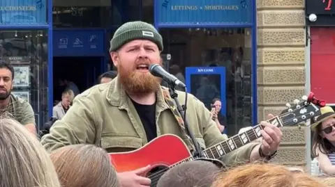 Brit Awards winner Tom Walker performs in Huddersfield town centre