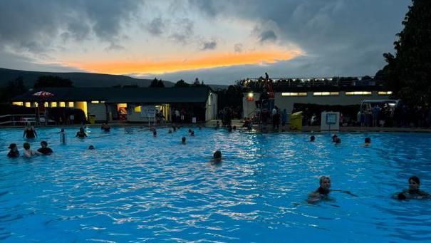 Hundreds brave the cold for full moon Ilkley Lido swim - BBC News