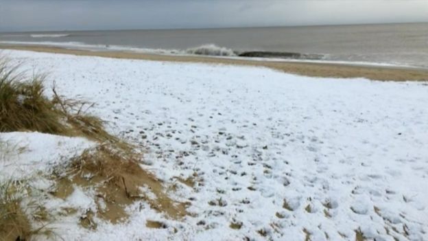 Snow falls on England's east coast beaches - BBC News