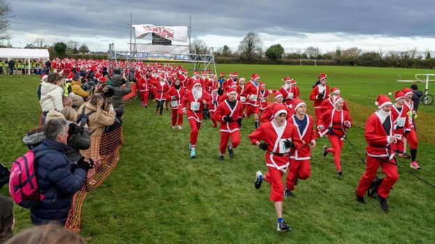 Hundreds of runners enjoy charity Santa Dash - BBC News