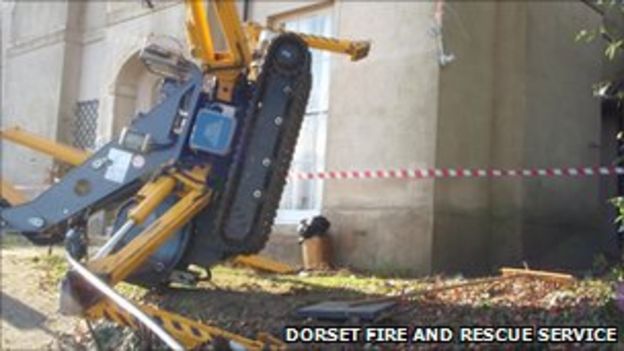 Two tree surgeons hurt as cherry picker falls over - BBC News