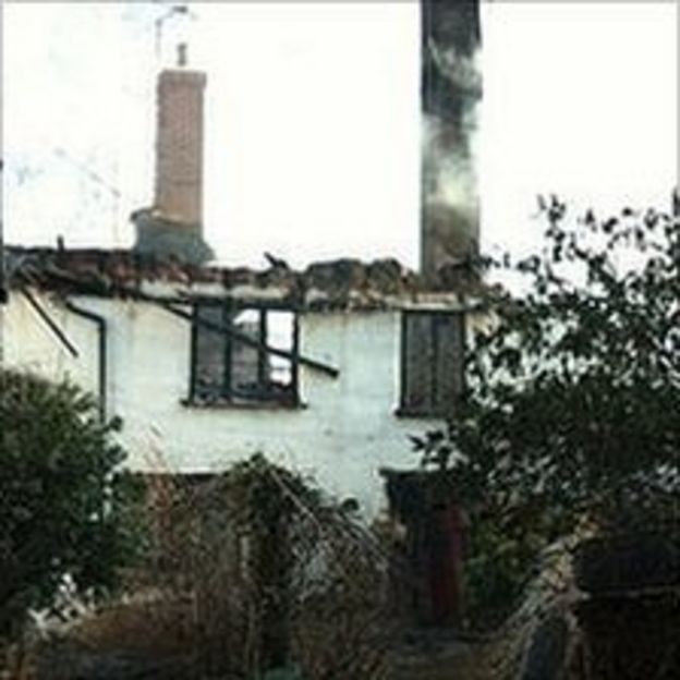 Fire crews damp down fire-damaged cottages in Crediton - BBC News