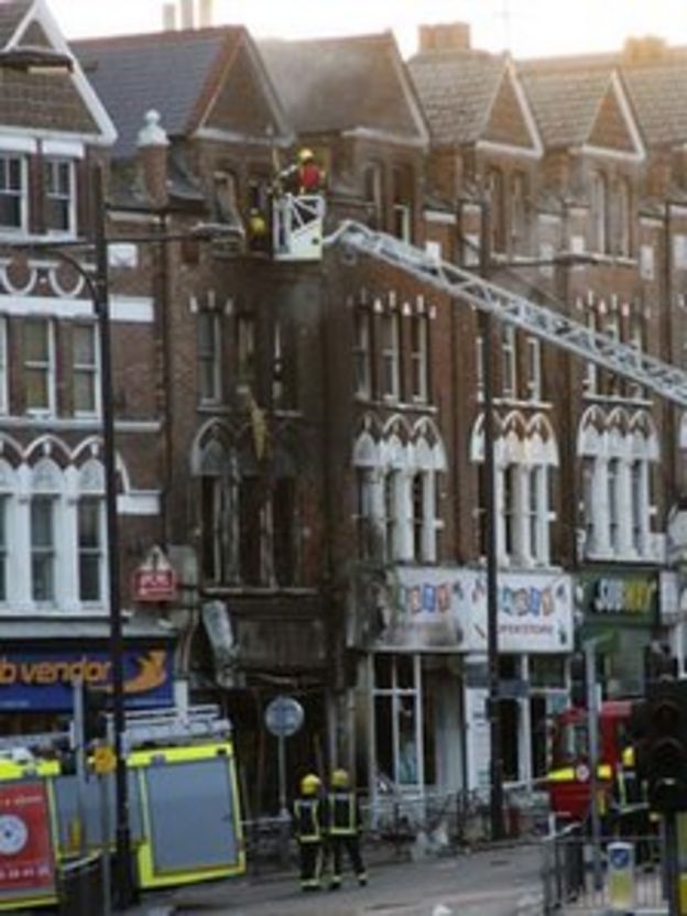 London riots: Fire-hit Clapham fancy dress shop reopens - BBC News