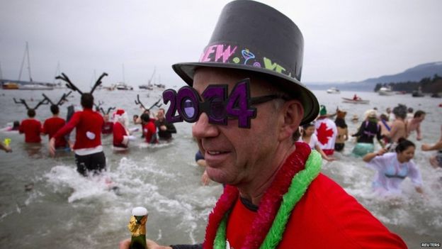 Swimming and singing: New Year in pictures - BBC News