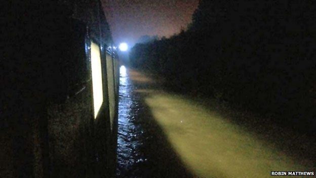 Train stuck in flood water after storms in southern England - BBC News