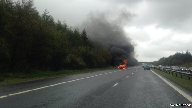 Three escape as car catches fire on M8 - BBC News
