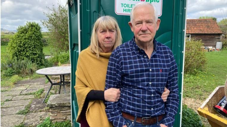 Flood forces couple to use temporary loo in garden - BBC News