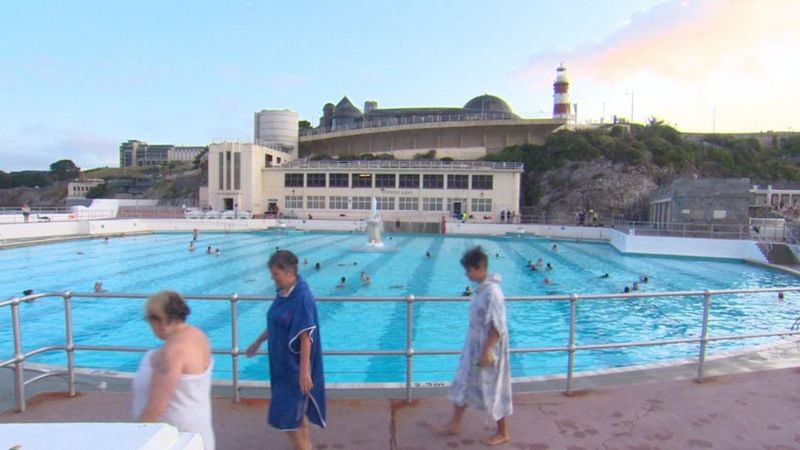 Hundreds join summer solstice sunrise swim in Plymouth - BBC News
