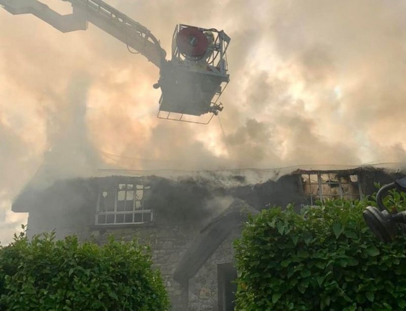 Crews tackle thatched house fire near Freshwater - BBC News