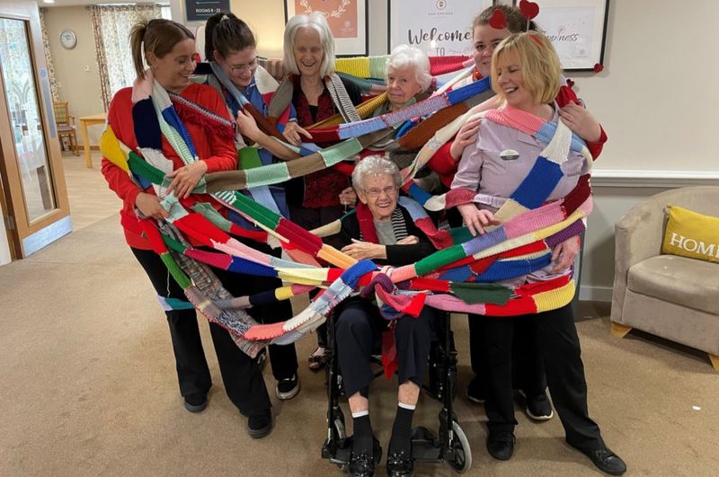 Huge scarf knitted at Liverpool care home for Dignity Action Day - BBC News