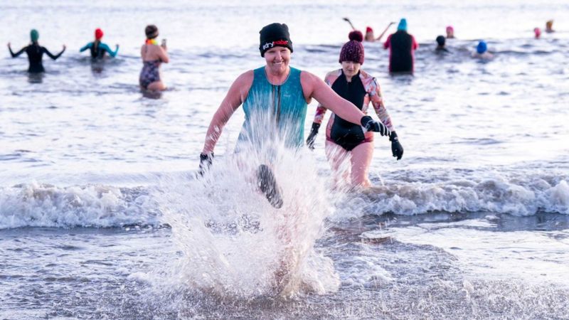 International Women's Day: Hundreds take part in sunrise swim - BBC News