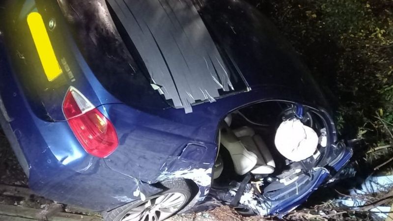 Driver cut free from car after crash into garden - BBC News