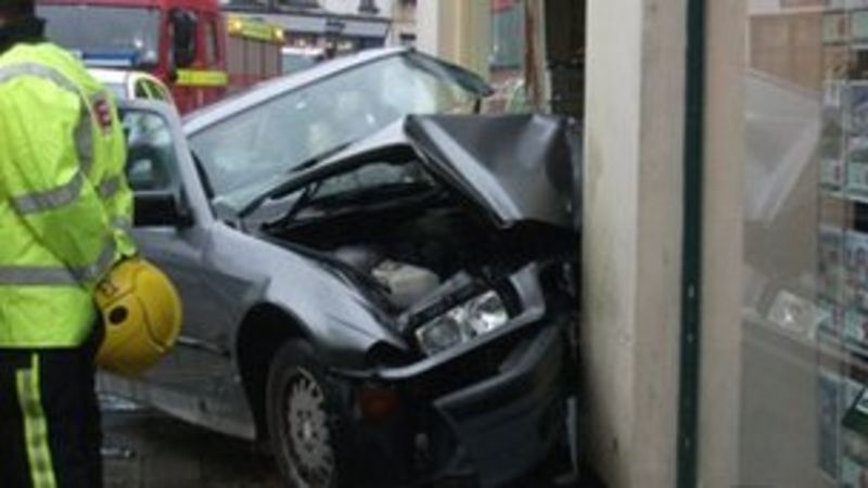 Two hurt as car crashes into Okehampton shop - BBC News