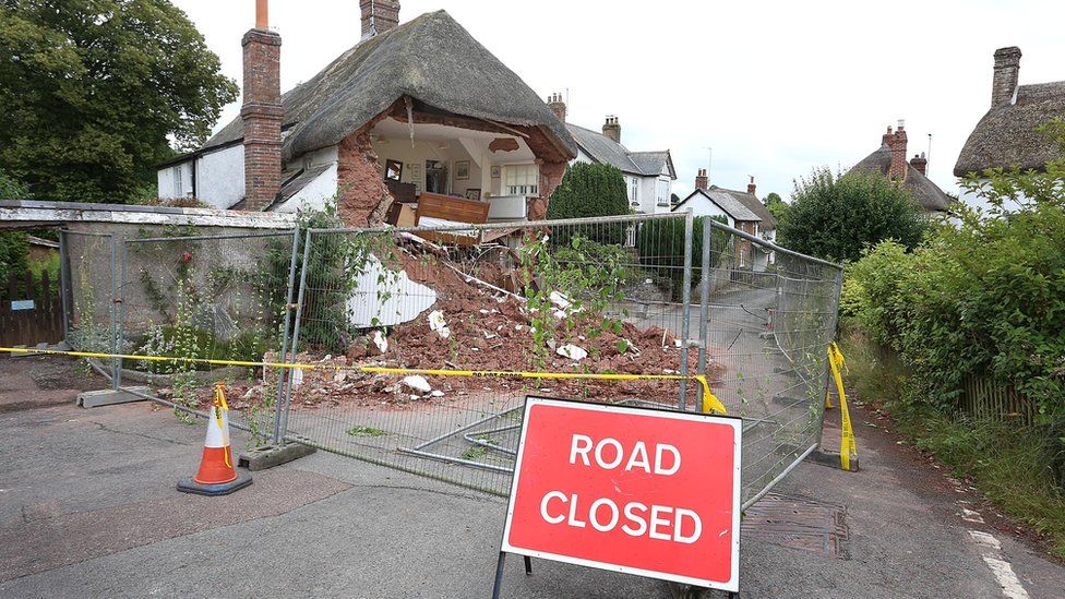 Gaping hole left in Devon house after cob wall collapse - BBC News