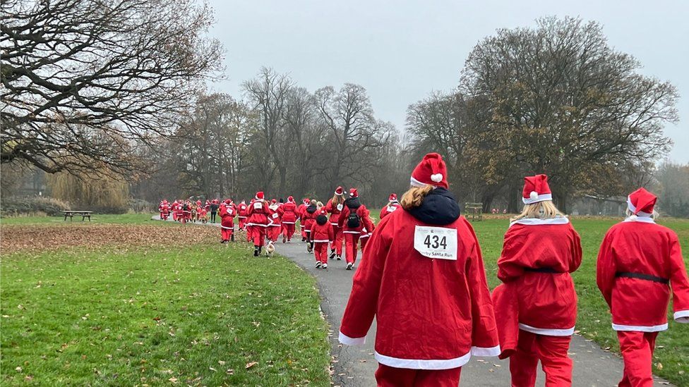 Derby Santa Run: Hundreds of festive runners race through park - BBC News
