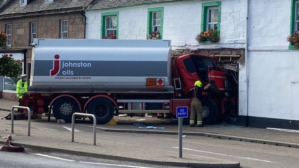 Oil tanker crashes into car and building in village - BBC News
