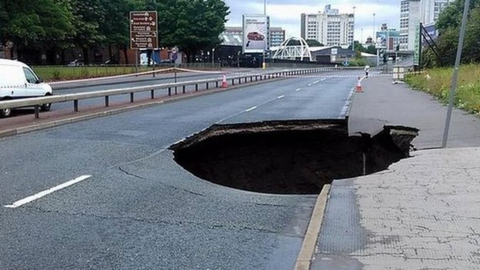 Manchester road collapse: Work begins to fill in huge hole - BBC News