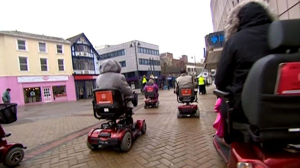 Luton mass mobility scooters in protest drive at funding cuts - BBC News