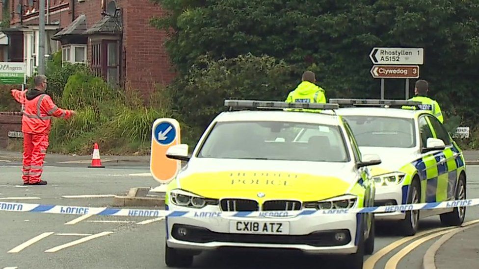 Wrexham crash: Driver held after doorman left seriously injured - BBC News