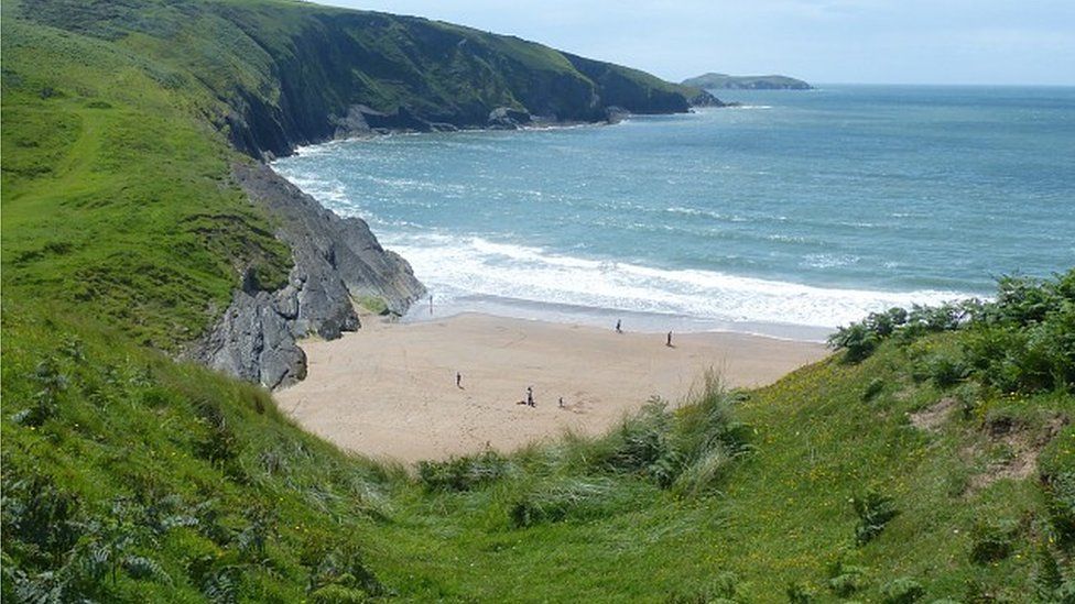 Search halted for man swept off rocks on Mwnt beach - BBC News