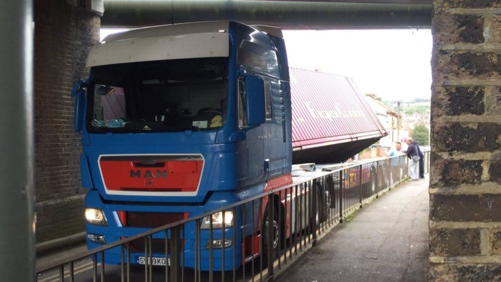 Lorry strikes railway bridge and sheds load - BBC News