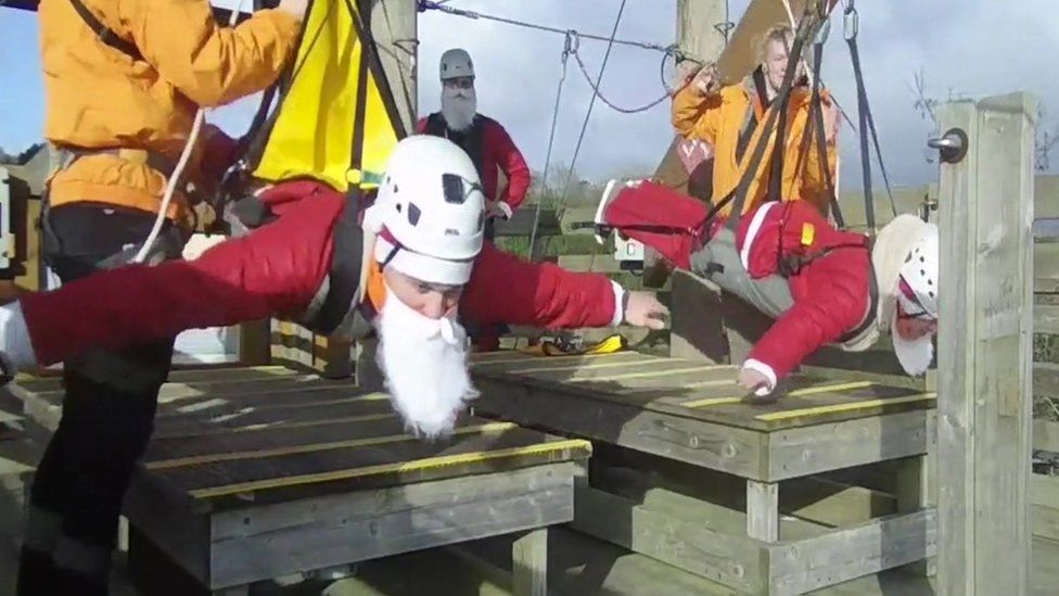 Derriford Hospital fundraisers take part in 'Santa Slide' - BBC News