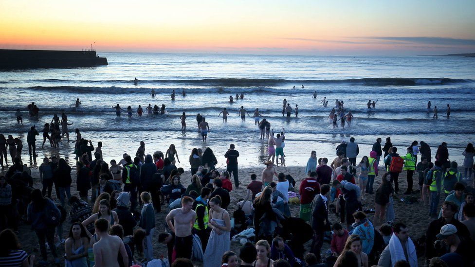 In pictures: Students dive in for May Day Dip - BBC News