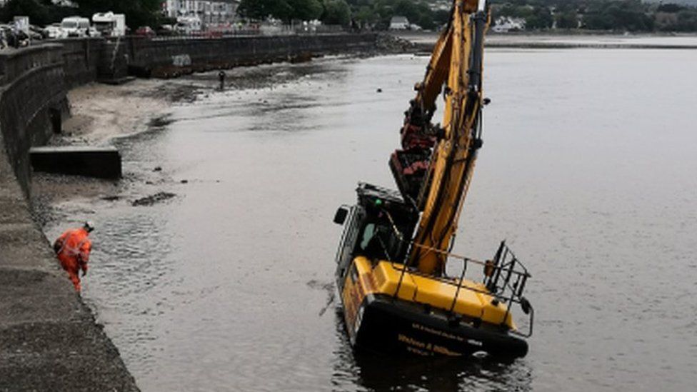 Mumbles: Digger left on beach swamped by high tide - BBC News