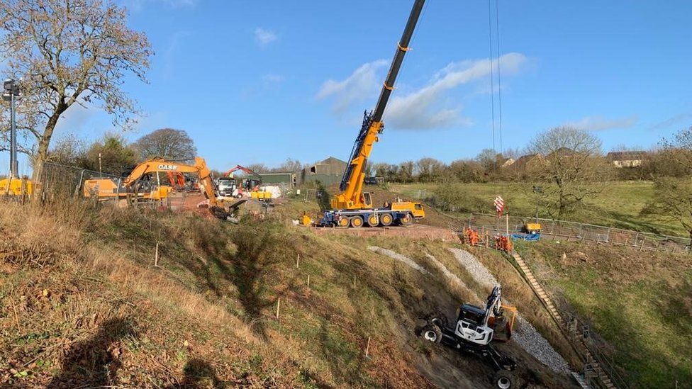 Work continues on Somerset railway line after Crewkerne landslip - BBC News