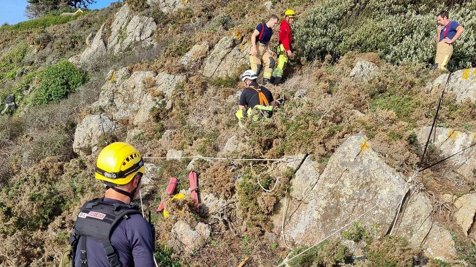 Stranded cliff climber rescued from Guernsey bay - BBC News