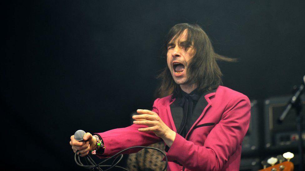 Primal Scream's Bobby Gillespie injures back in fall from stage - BBC News