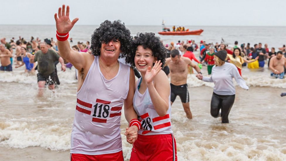 Swimmers brave sea as Sheringham's New Year's Day Dip returns - BBC News