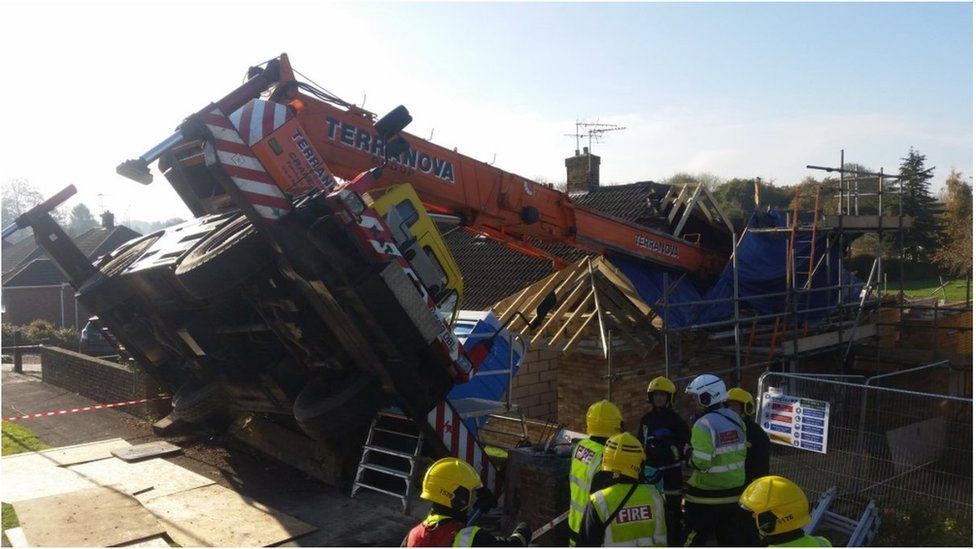 Driver trapped as crane falls on house in Basingstoke - BBC News