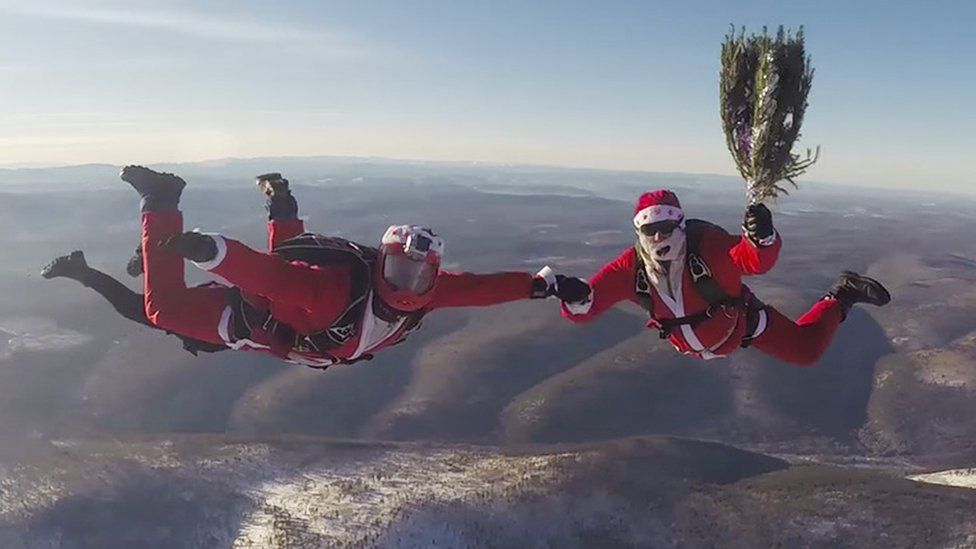 Siberia Santas sky-dive with tree and wine for New Year - BBC News