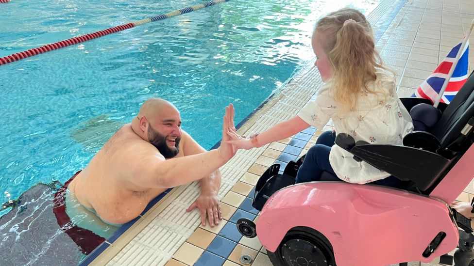 Fastest person walking in swimming pool raises charity money - BBC News