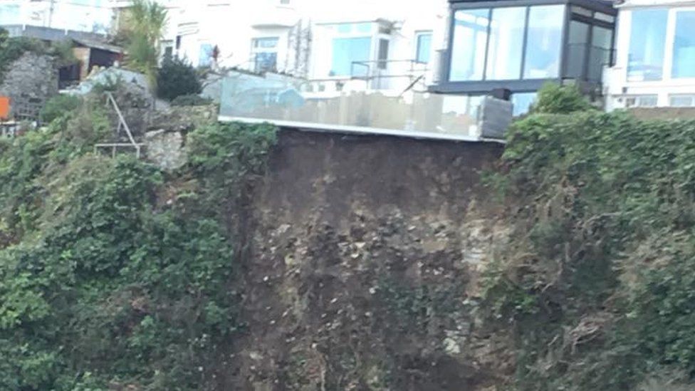 Cliff collapses under garden balcony in Newquay - BBC News