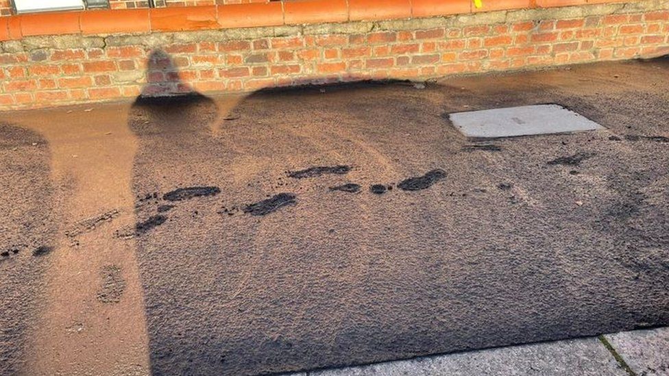 Footprints left in wet tar after workers fail to rope off pavement ...
