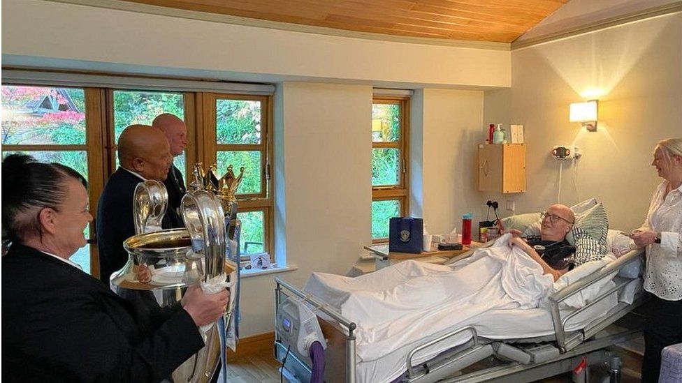 Manchester City's treble trophies taken to patient's bedside - BBC News