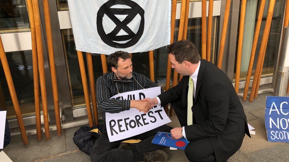 Climate activists chain themselves to Scottish Parliament - BBC News