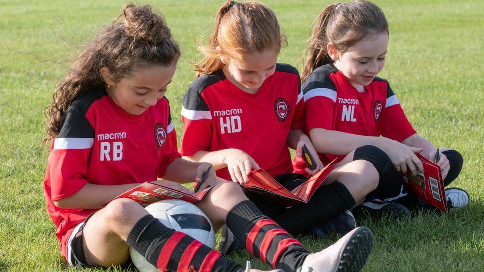 Dad makes sticker album for daughter's Rothwell football team - BBC News