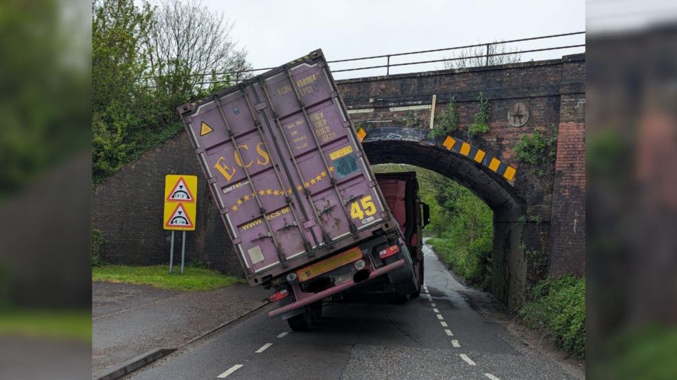 Lorry lodged under bridge as driver fined for careless driving - BBC News