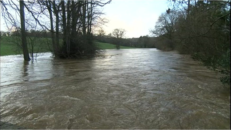 Bridge submerged as flooding affects parts of Wales - BBC News