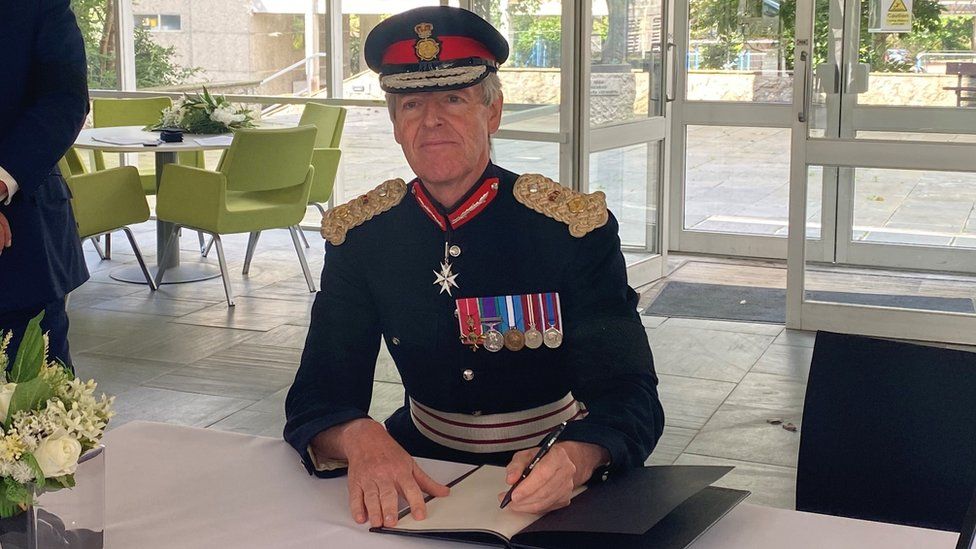 Books of condolence open and flags at half-mast in South West - BBC News