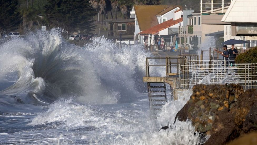 Surfers take on giant waves as storm hits California - BBC News
