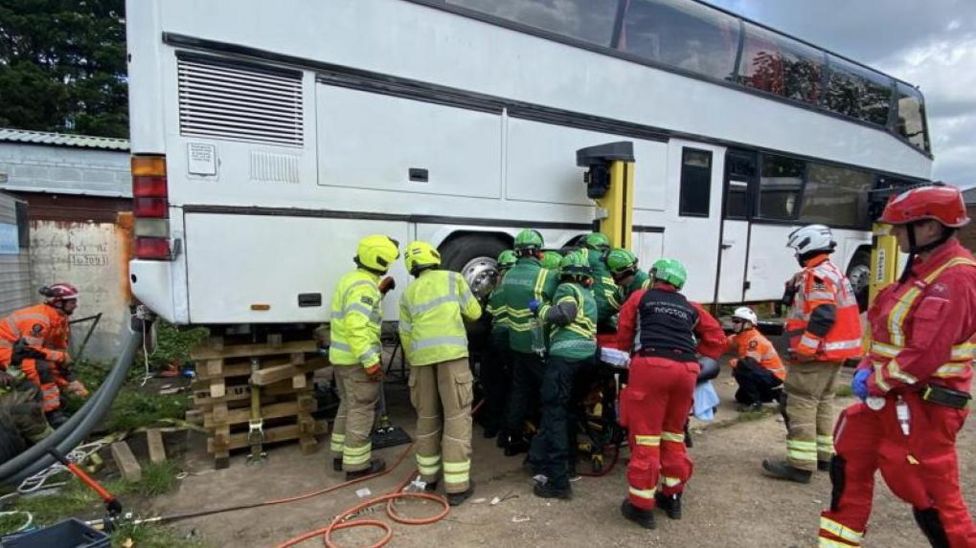 Trapped man rescued from under Roydon double-decker bus - BBC News