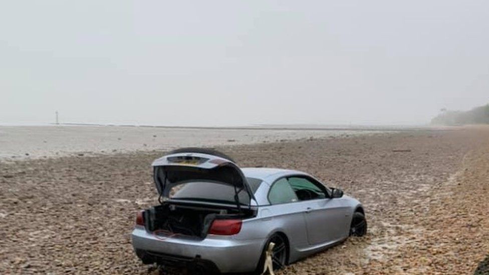Car submerged by sea after rolling on to beach in Hampshire - BBC News