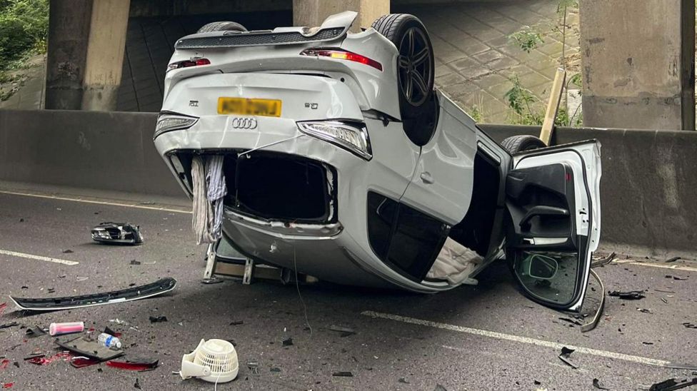 Driver arrested after car crashes off interchange flyover - BBC News