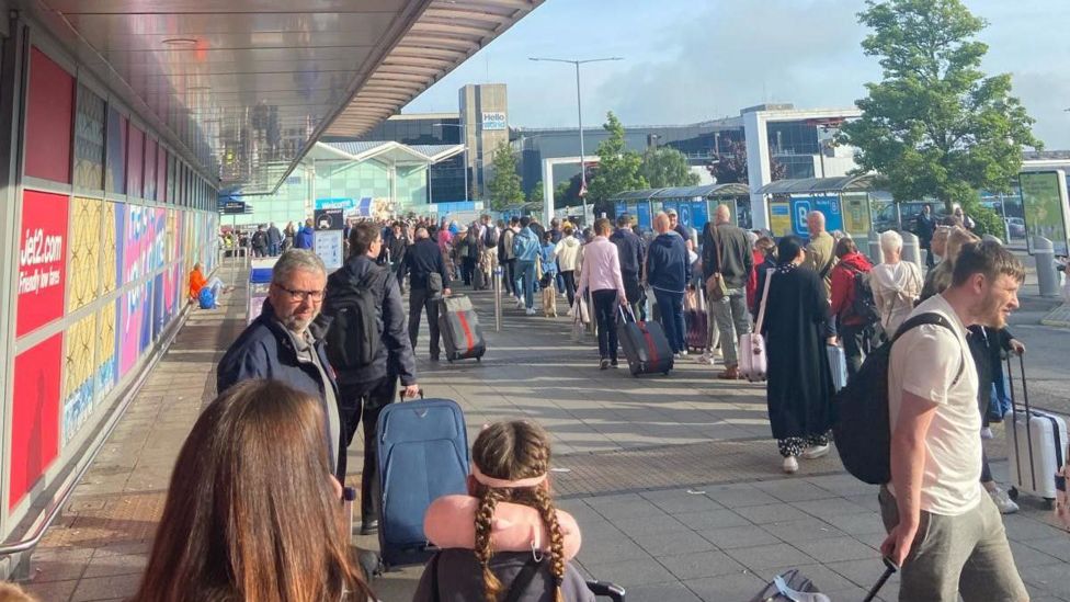 Passengers in long outdoor queues at Birmingham Airport - BBC News